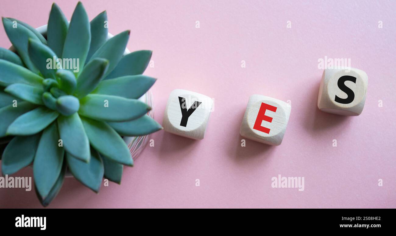 Yes symbol. Wooden blocks with word yes. Beautiful pink background with ...