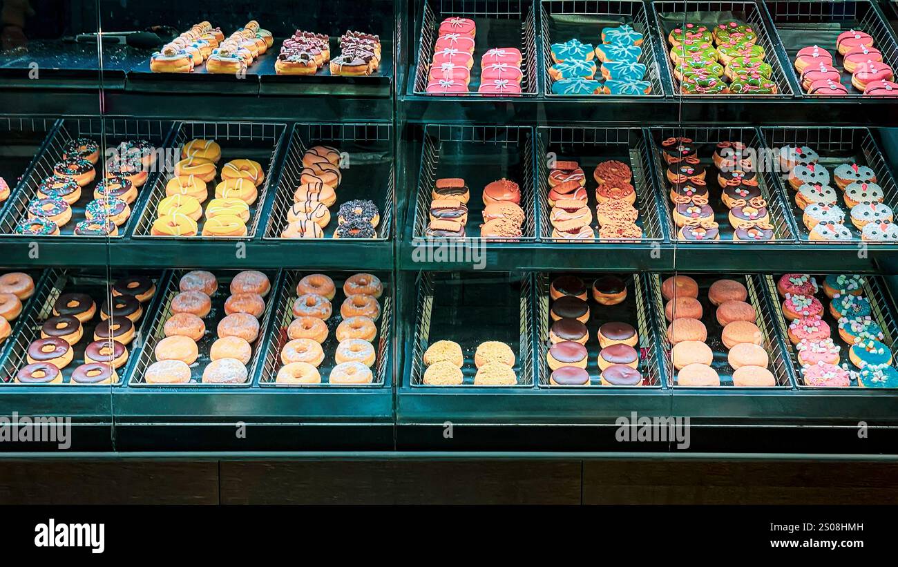 Display case filled with colorful donuts of various shapes and ...