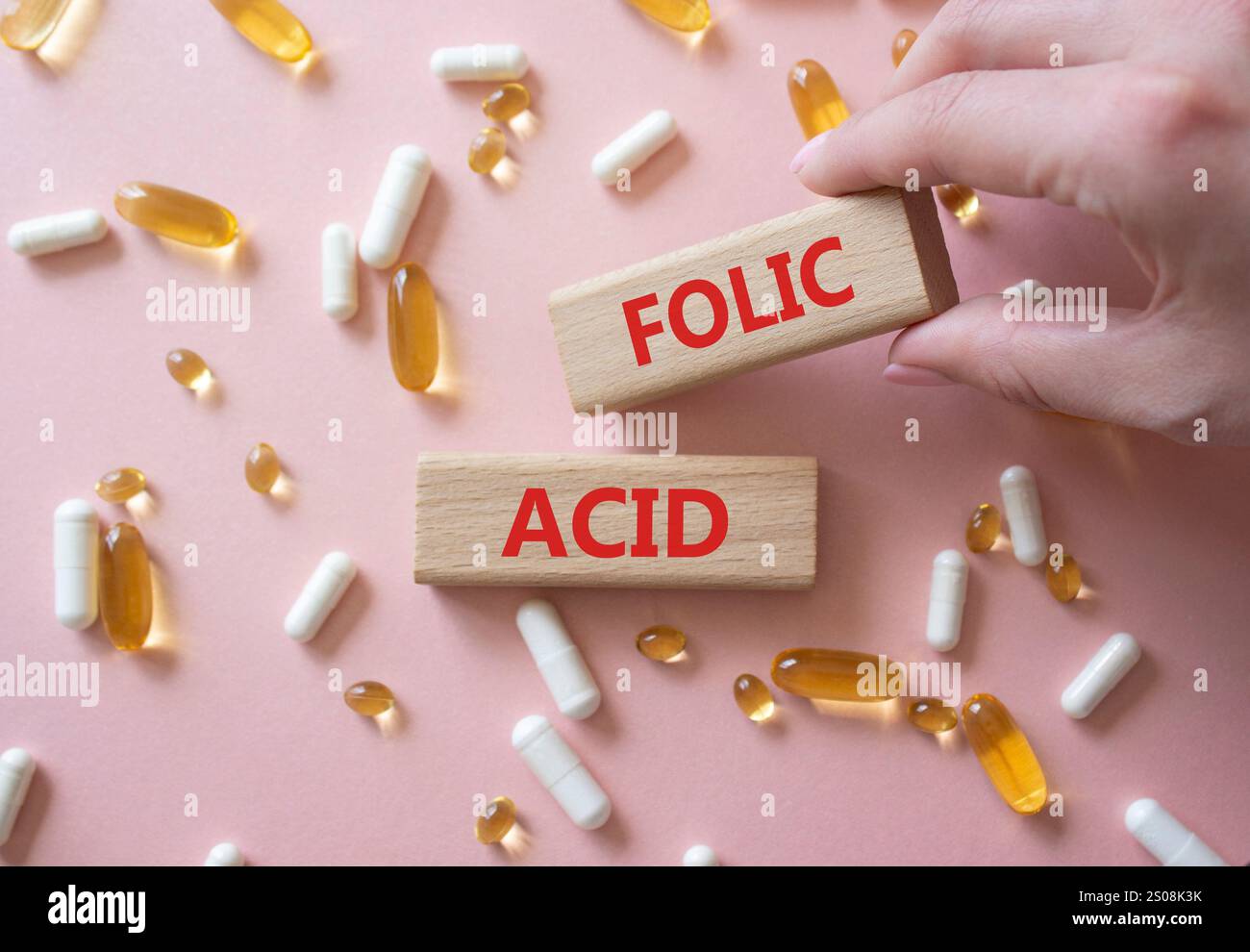 Folic acid symbol. Wooden blocks with words Folic acid. Beautiful pink ...