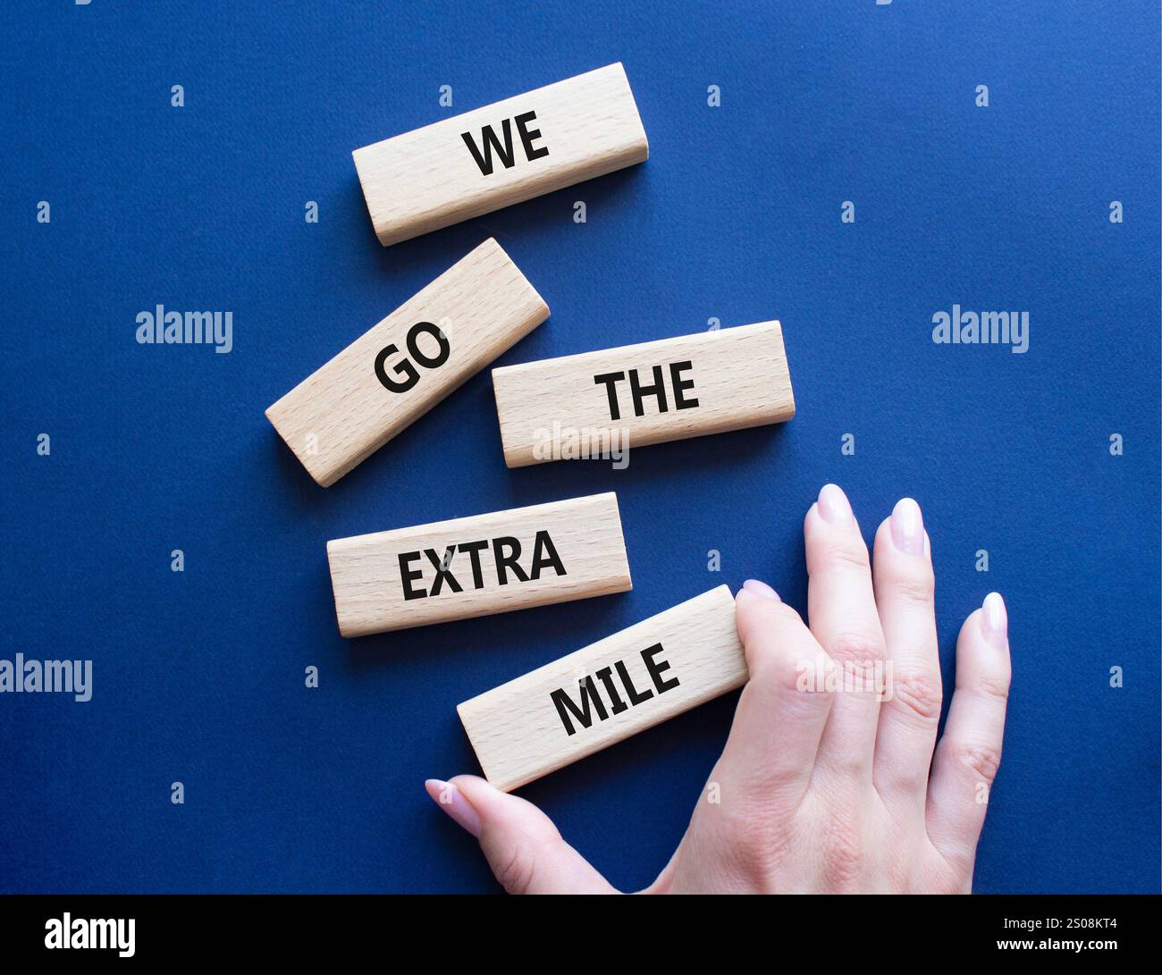 We go the extra mile symbol. Wooden blocks with words We go the extra ...
