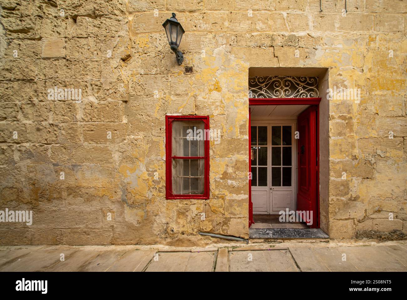 Traditional house detail in Malta. Limestone yellow bricks and colorful ...