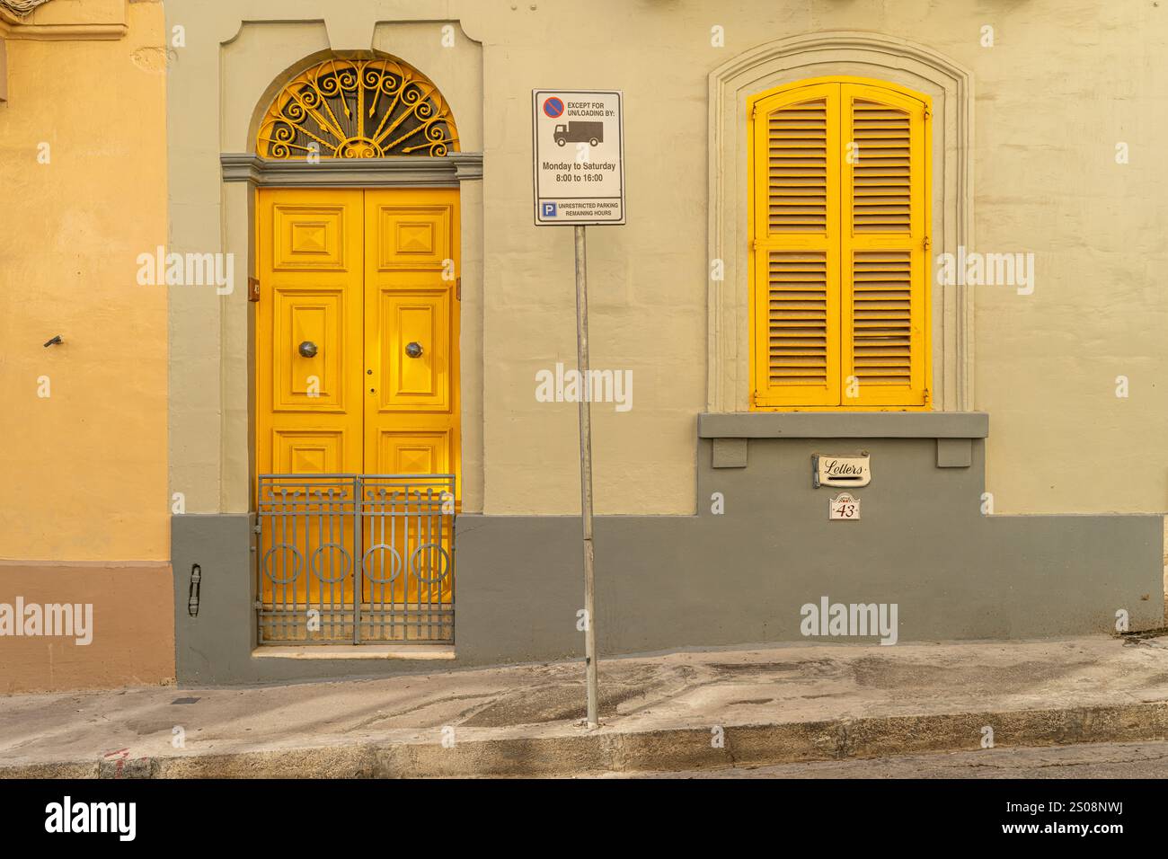 Traditional house detail in Malta. Limestone yellow bricks and colorful ...