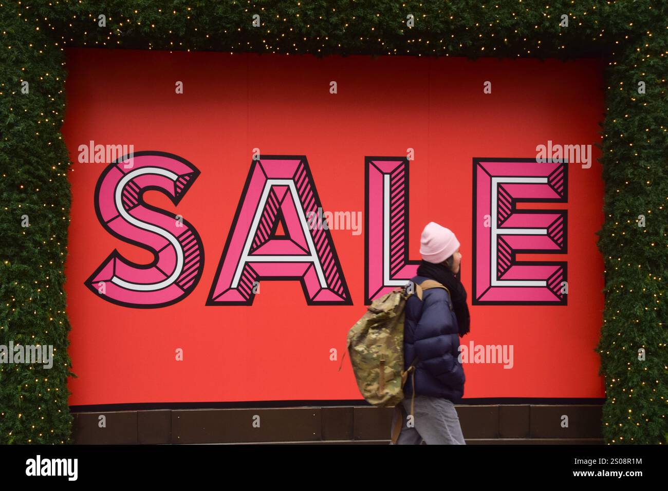 A woman walks past a 'Sale' sign at Selfridges on Oxford Street as ...