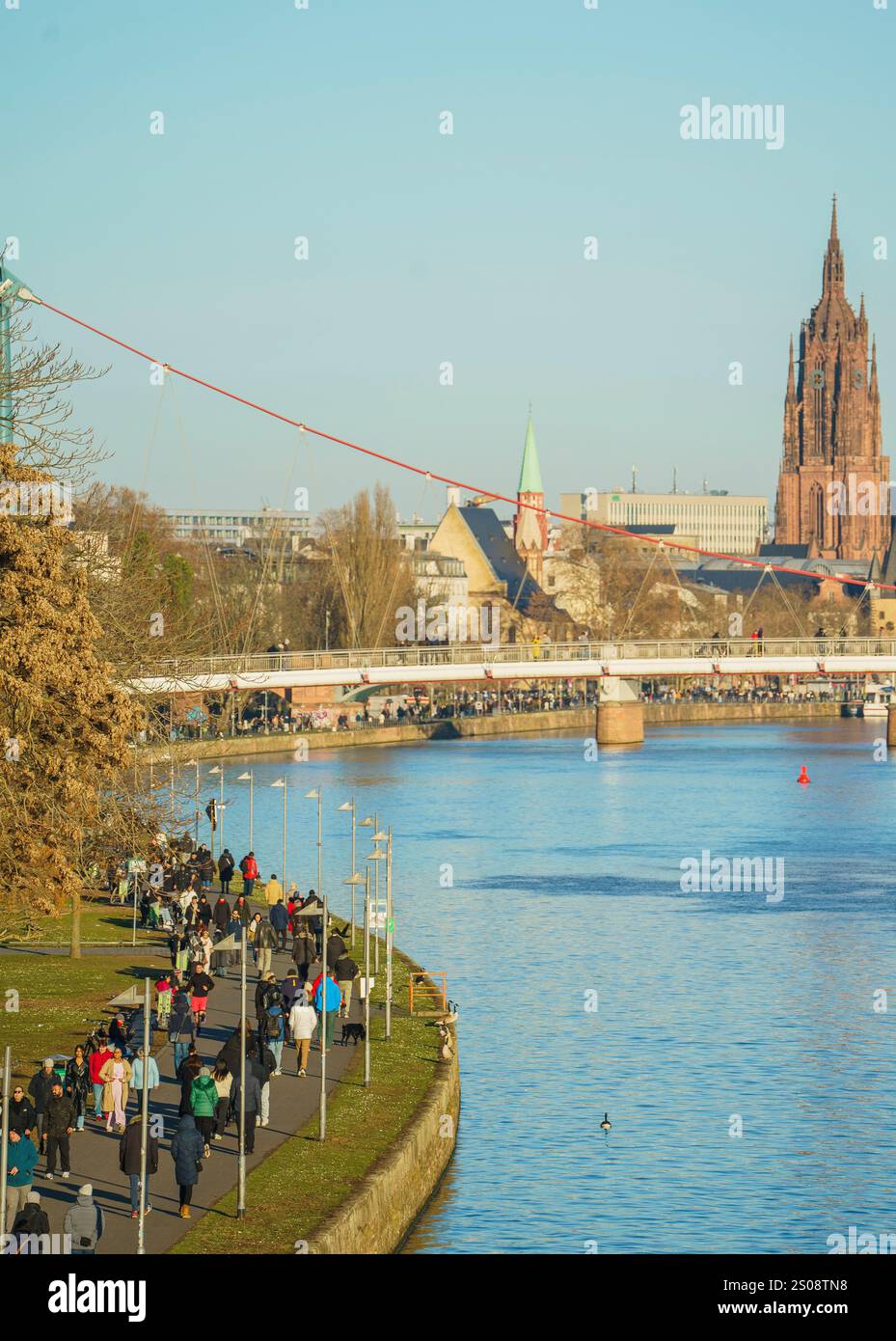 26 December 2024, Hesse, Frankfurt/Main: People stroll along the banks ...