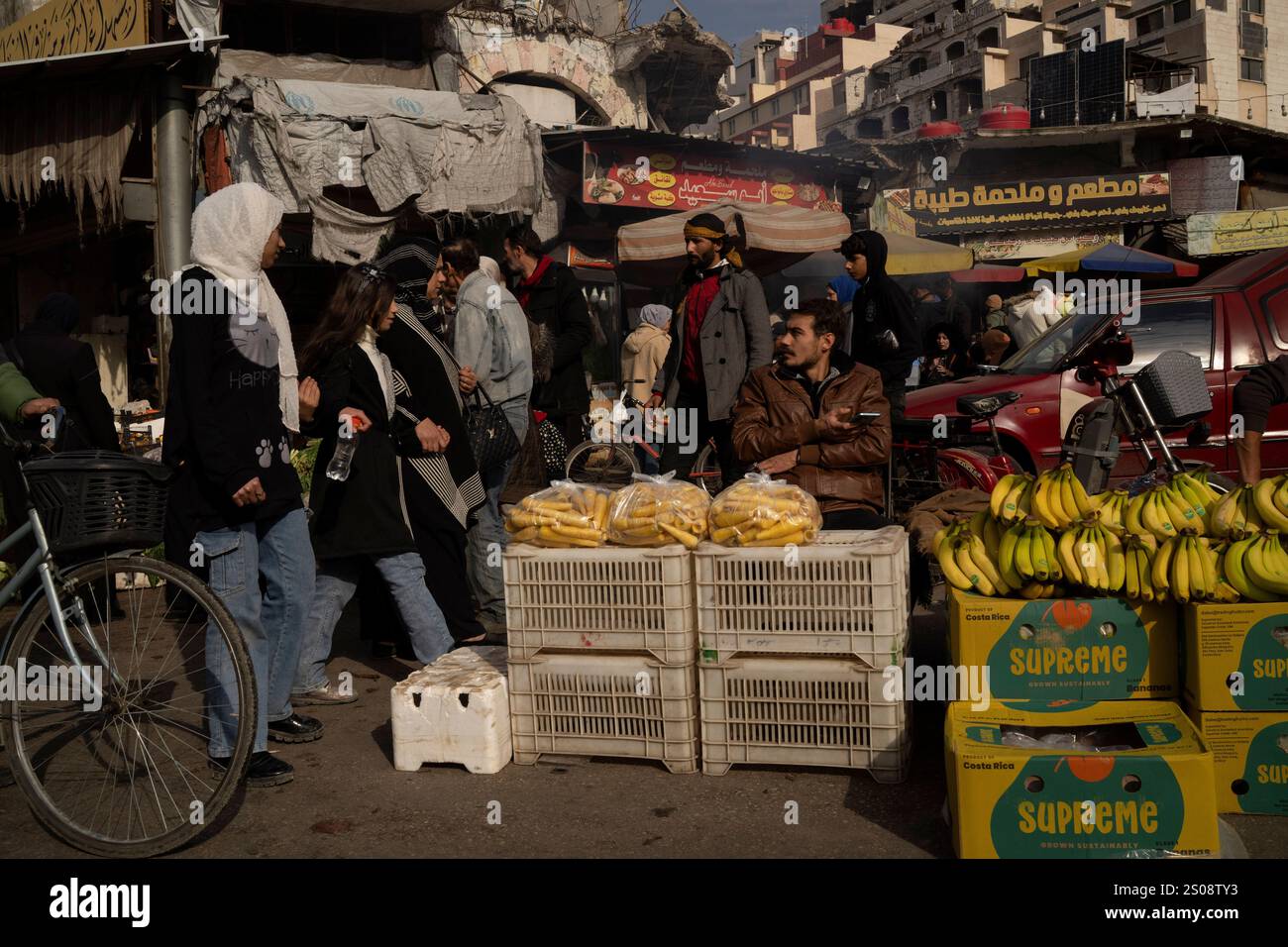 People walk on by a street market in downtown Homs, Syria, Thursday ...