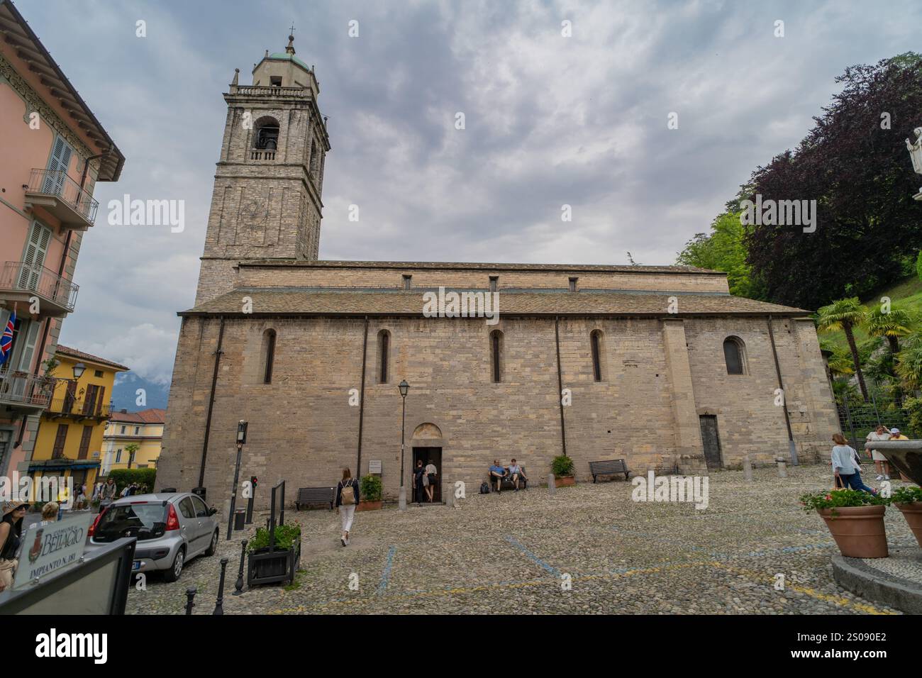 Historic stone church with a bell tower in a cobblestone plaza ...