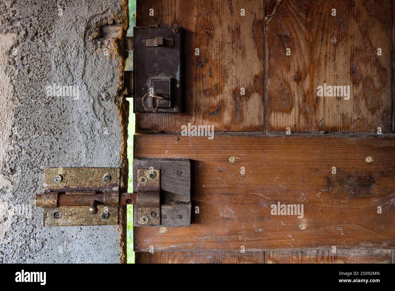 A wooden door with a bolt and a metal lock. The door is closed and the ...