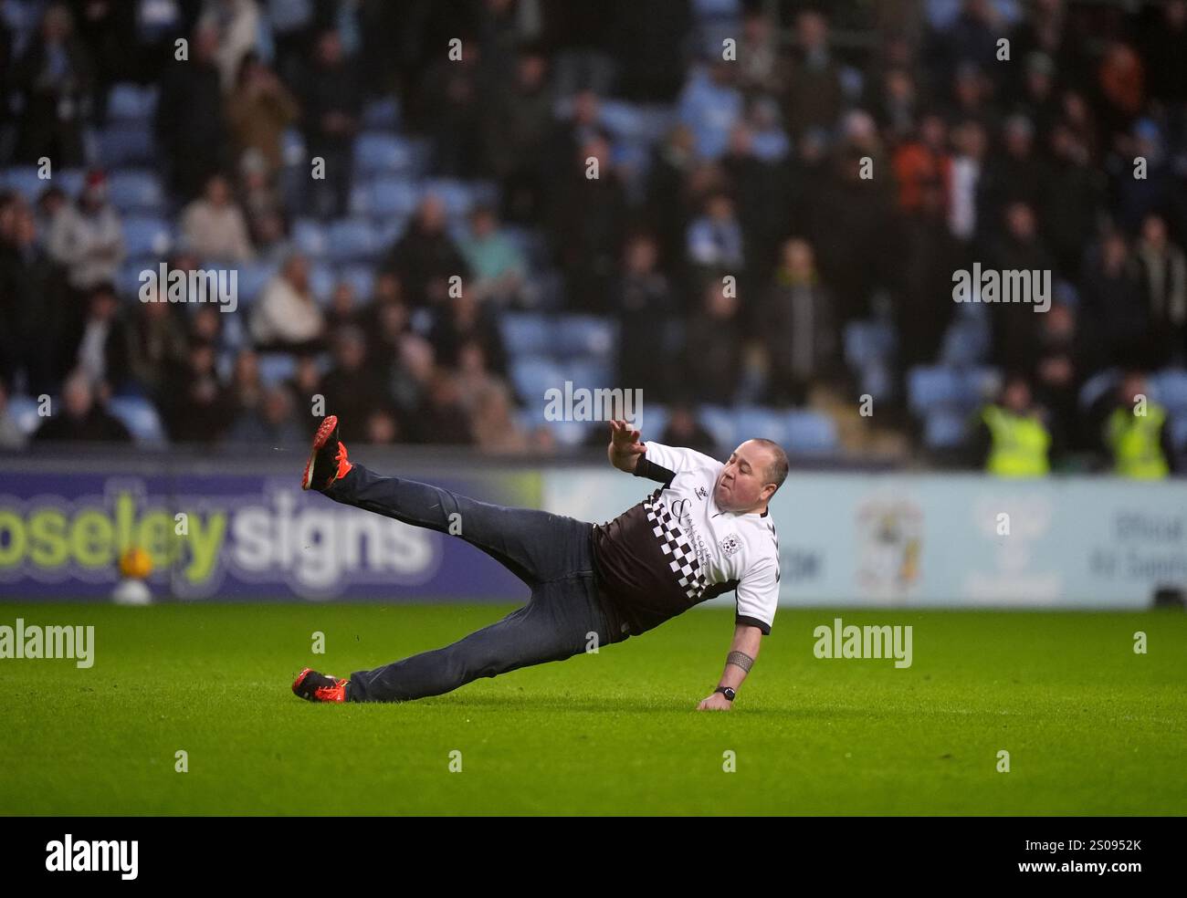 A fan taking part in the Kick it for a Ticket game on the pitch at half ...