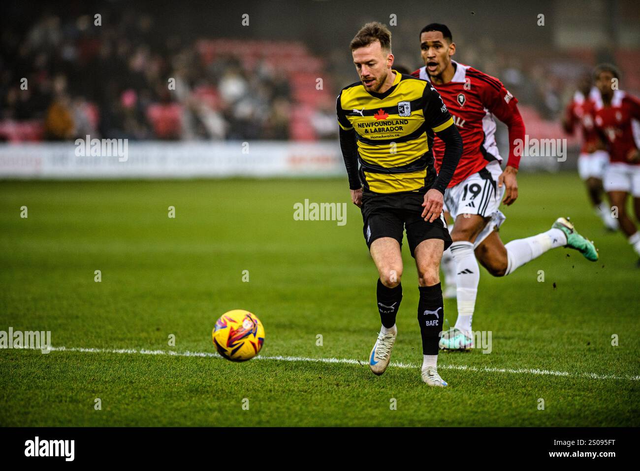Elliot Newby of Barrow AFC tries to outrun Haji Mnoga of Salford City ...