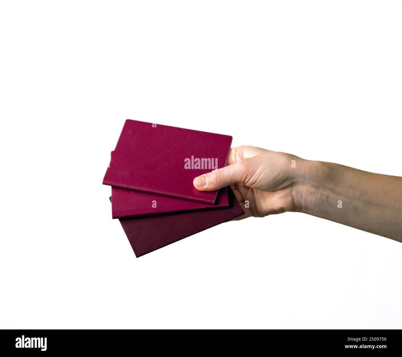 A close-up shot of a hand holding passports, against a clean white ...