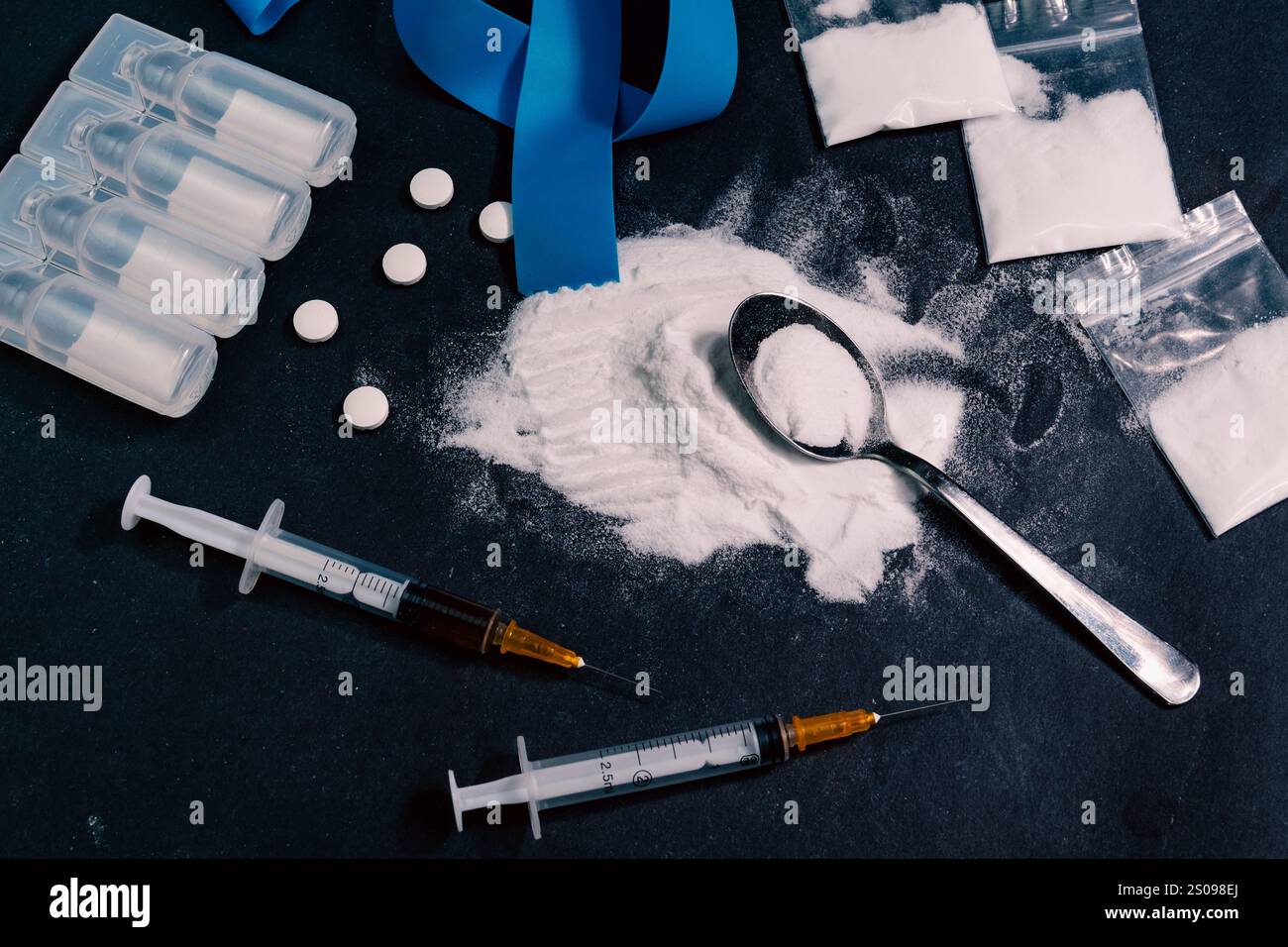 Drug addiction concept. Bags of heroin, tablets, ampoules and syringes ...