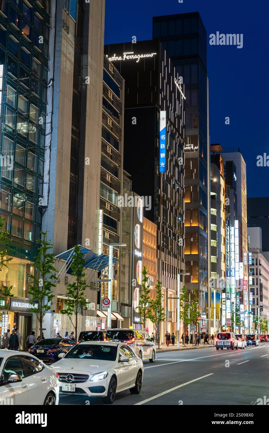 Night view along the famous Ginza shopping street with row of high rise ...
