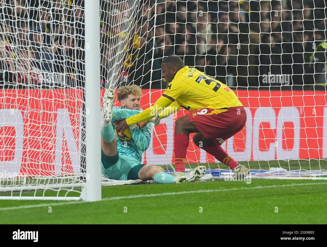Watford's Edo Kayembe scores a penalty and tries to retrieve the ball ...