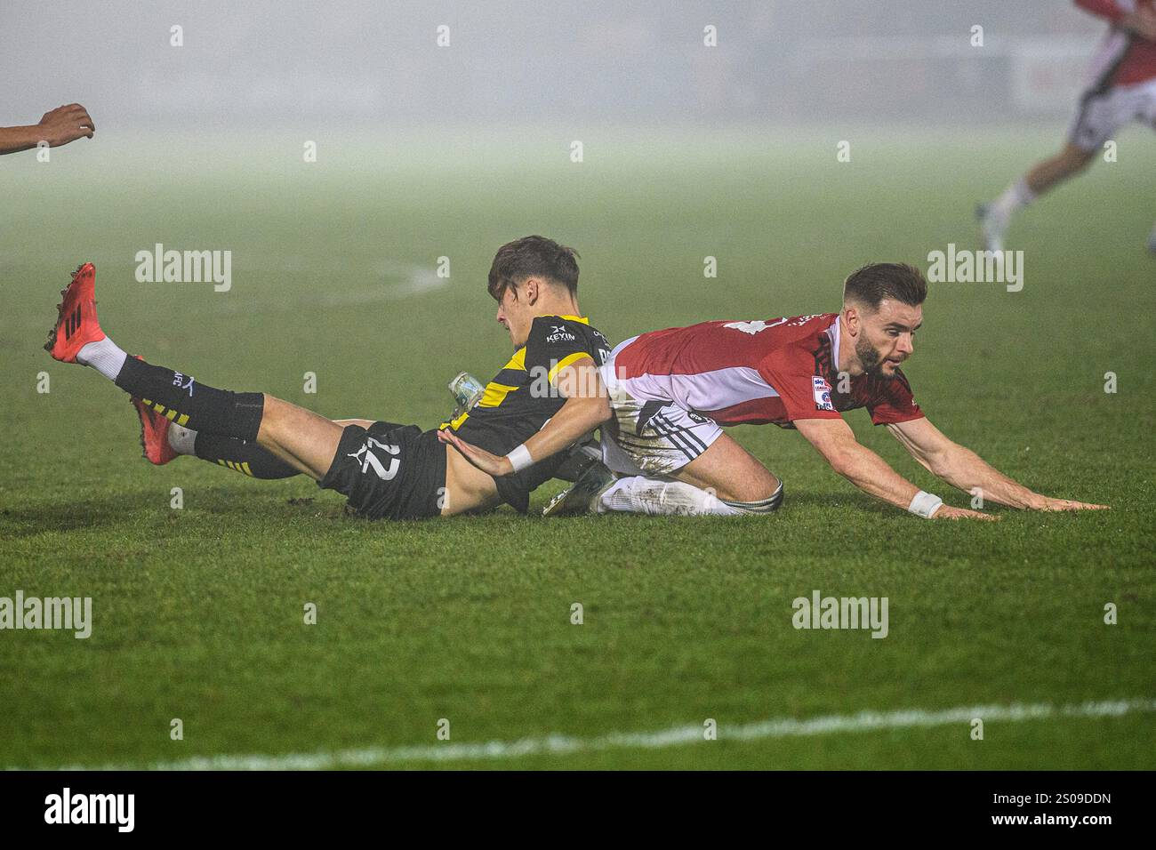 Chris Popov of Barrow AFC and Luke Garbutt of Salford City FC collide ...