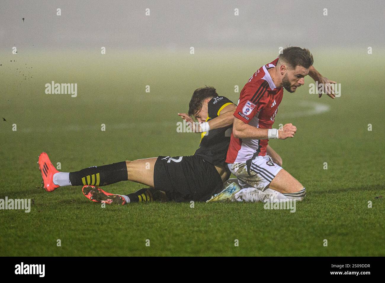 Chris Popov of Barrow AFC and Luke Garbutt of Salford City FC collide ...