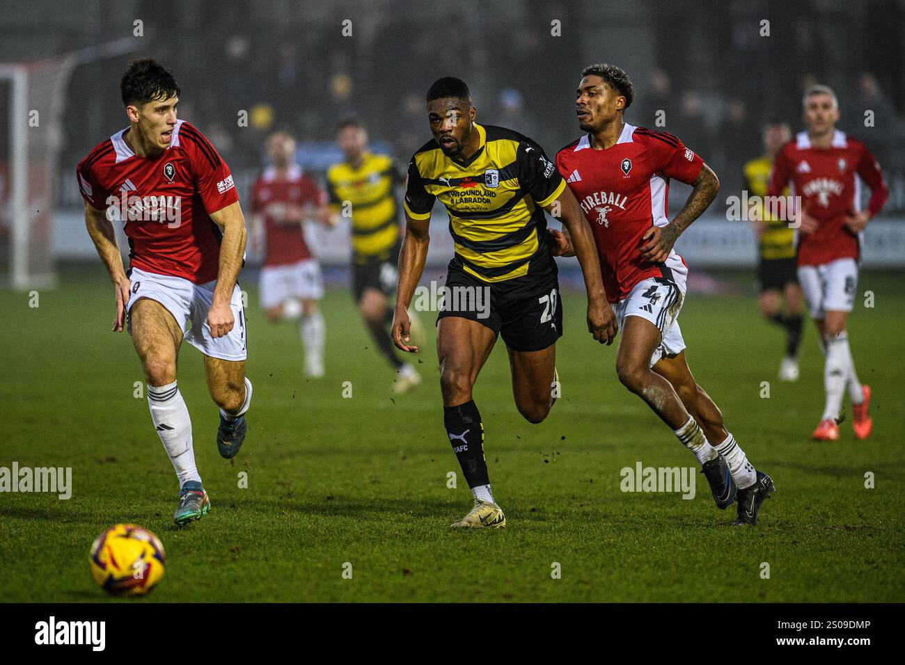 Emile Acquah of Barrow AFC makes a run under pressure from Stephen Negru and Ossama Ashley of ...
