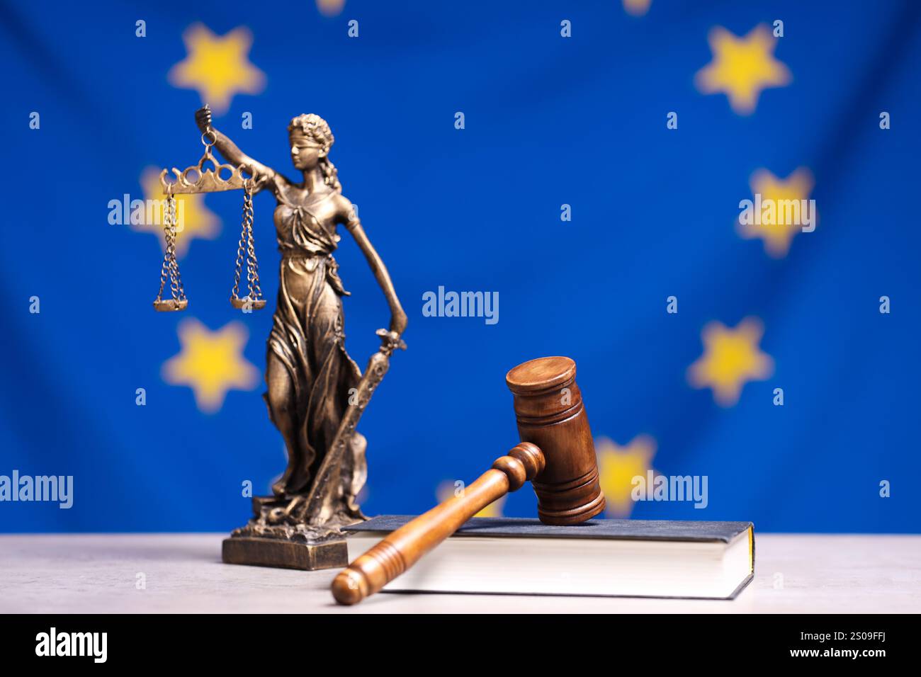 Judge's gavel, book and figure of Lady Justice on table against ...