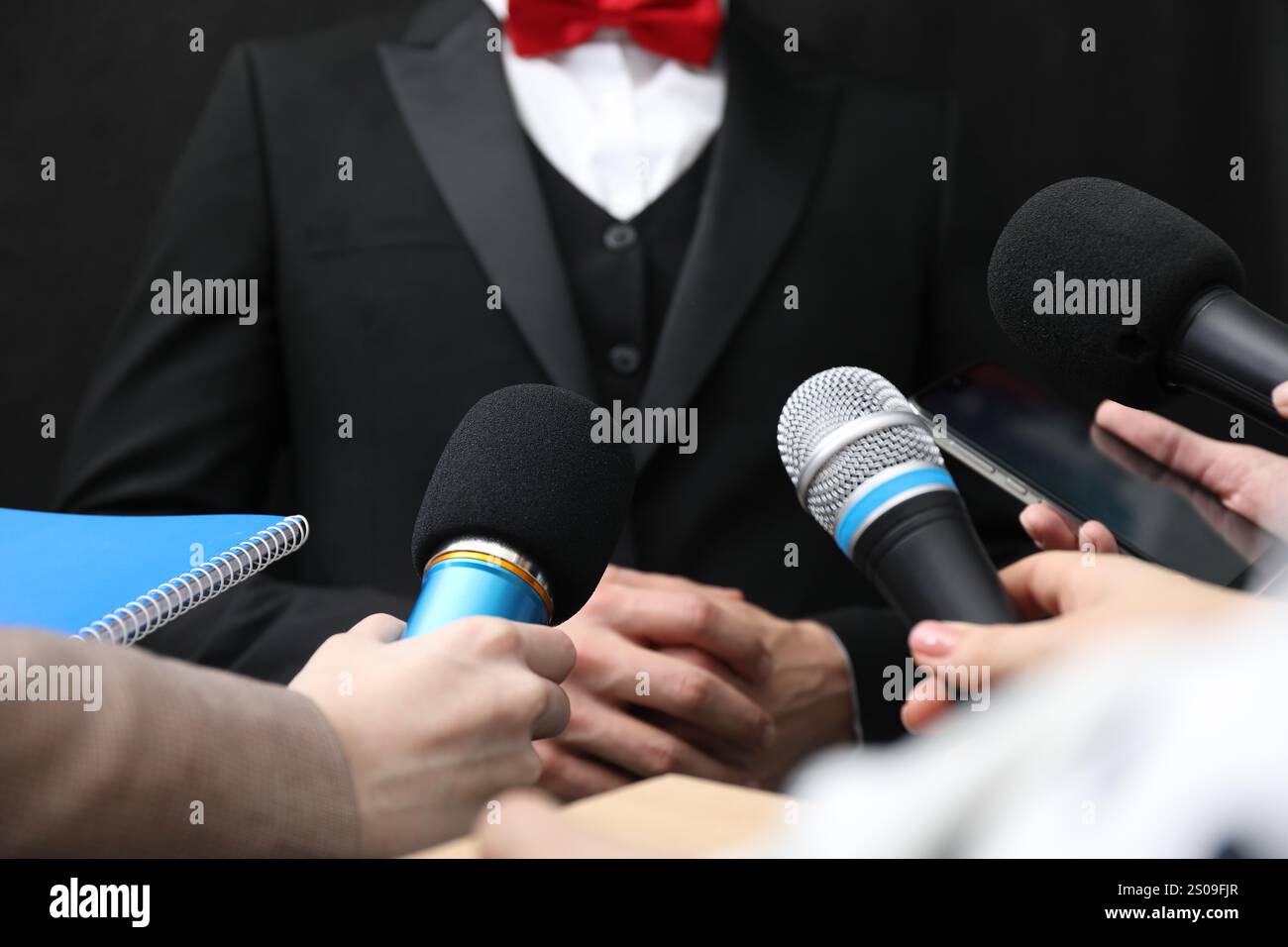Group of journalists interviewing businessman on black background ...
