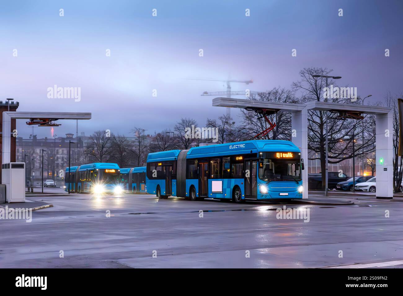 The modern blue buses are located in an urban setting during the ...