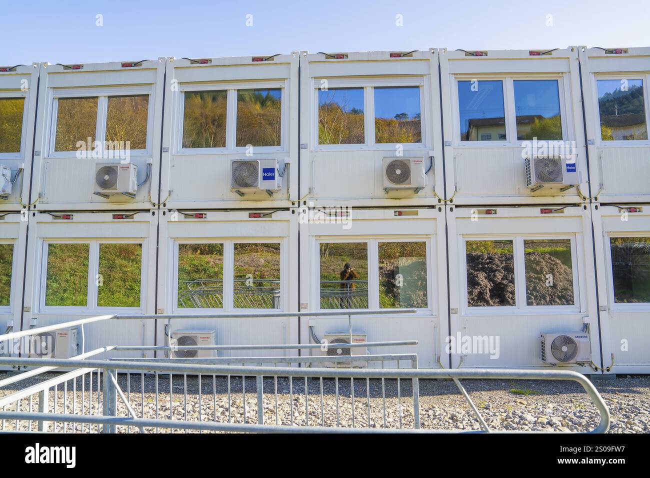 Side view of white containers with rows of windows and air conditioning ...