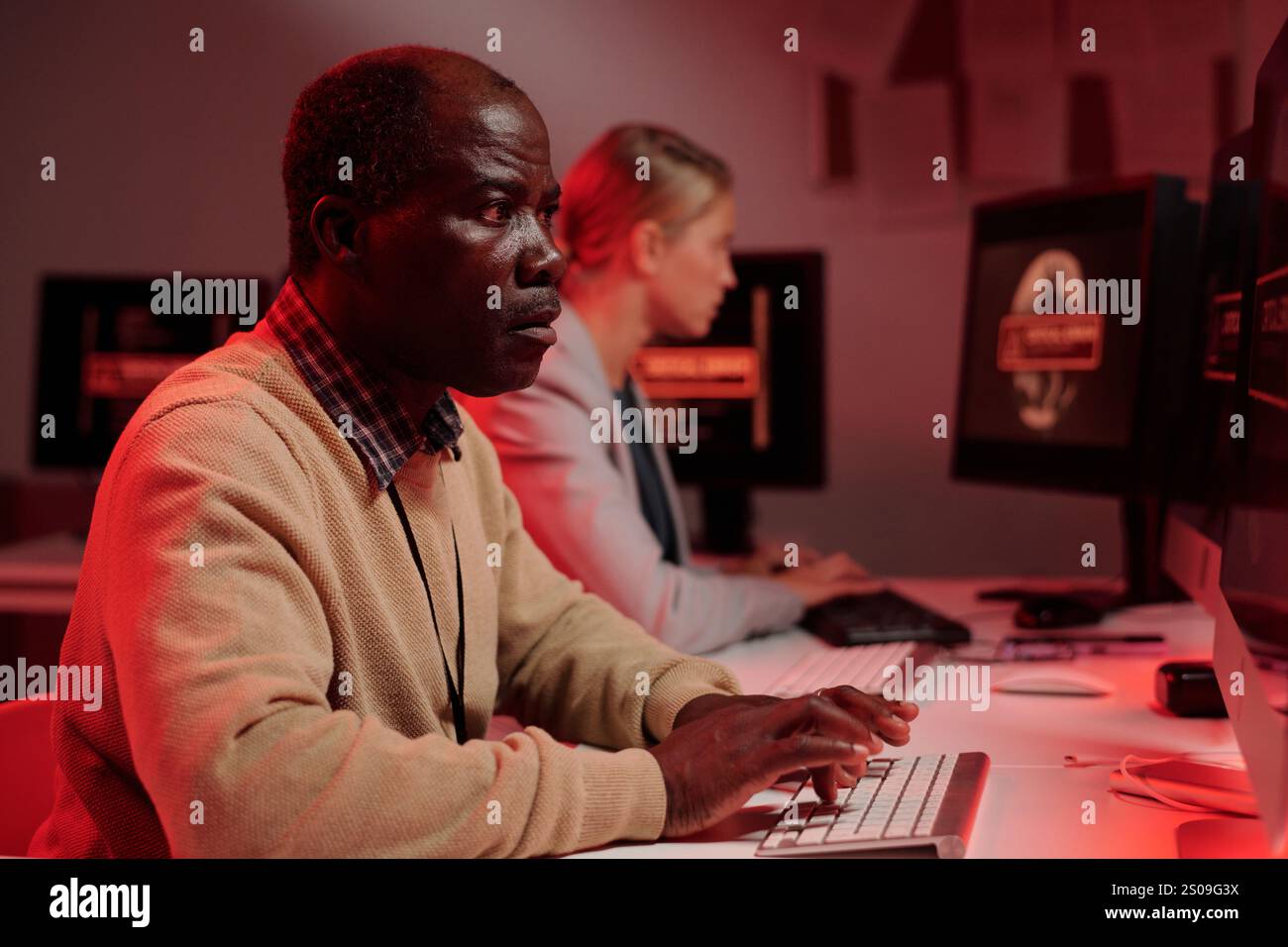 Side view of serious mature security guard trying to solve technical ...