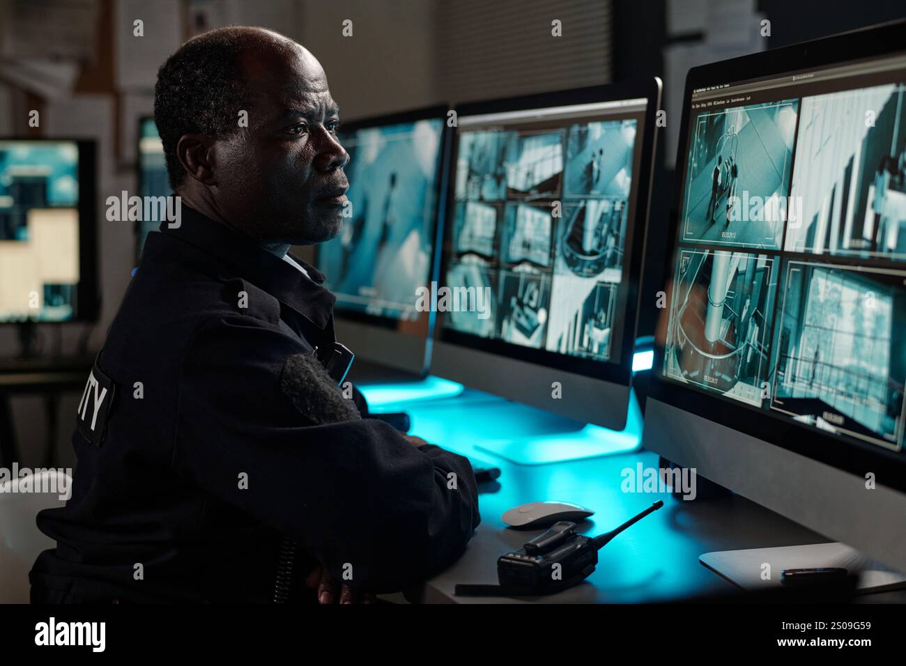 Mature male security guard concentrating on watching cctv video on ...