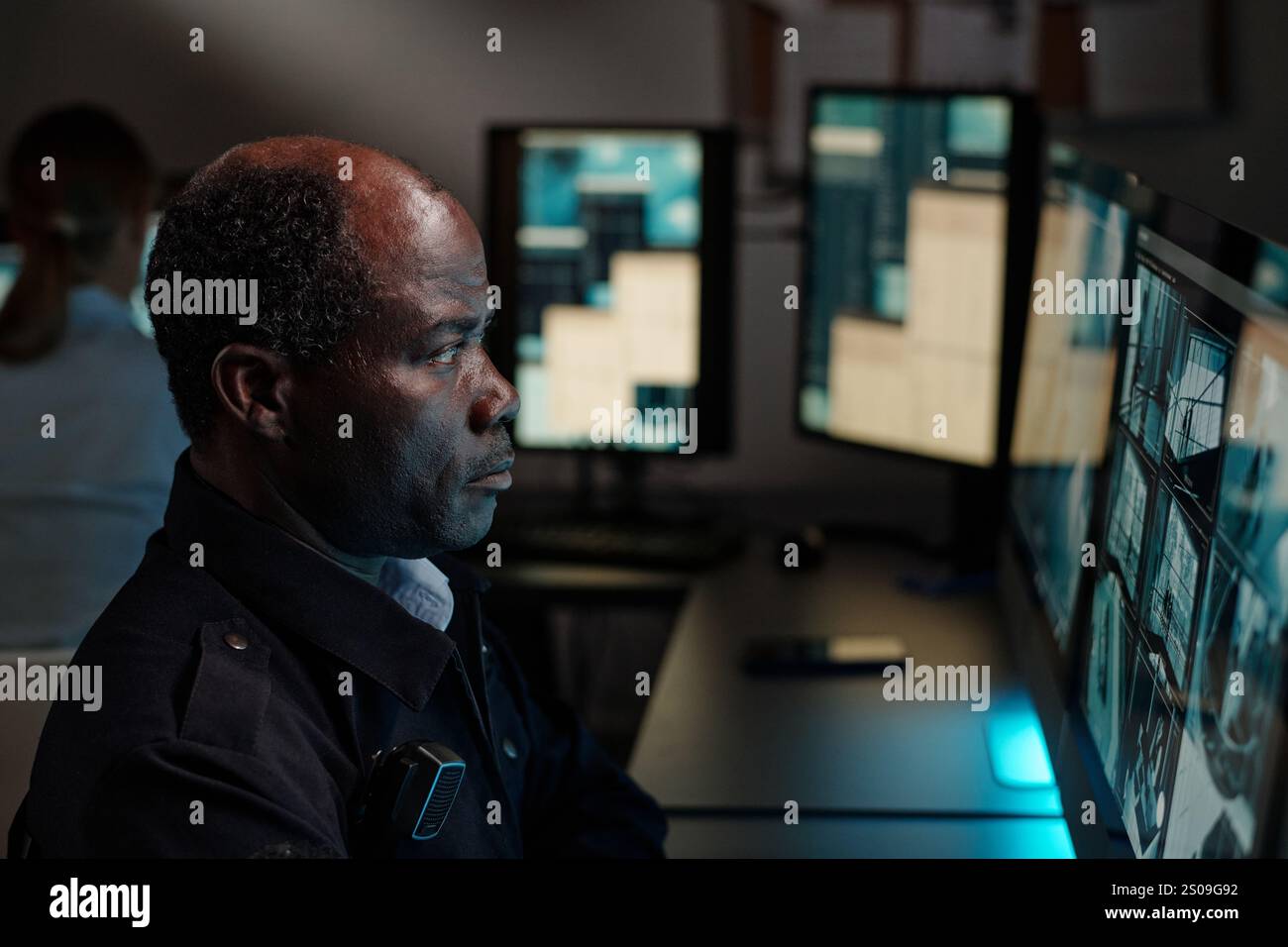 Mature African American security guard concentrating on watching cctv ...