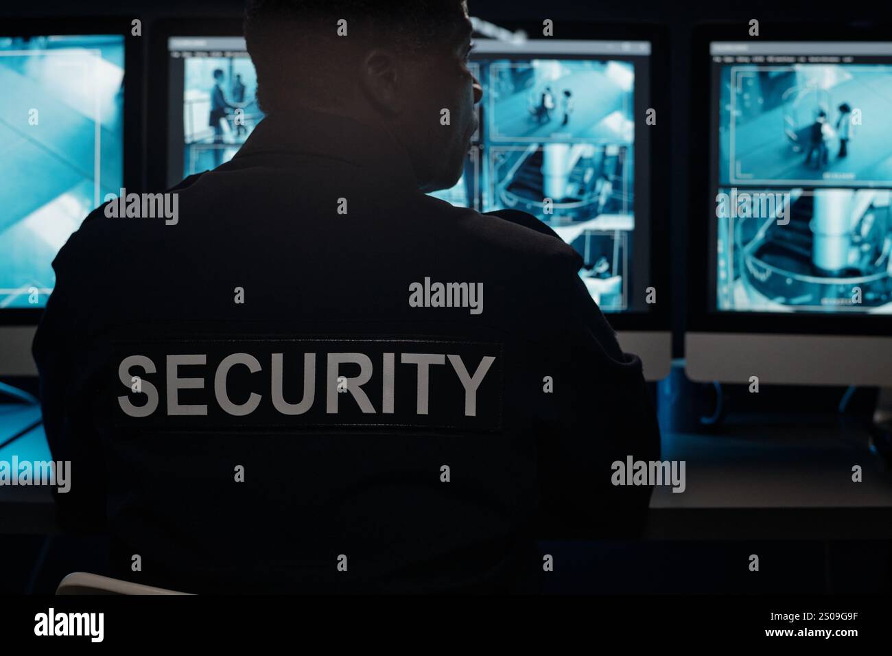 Back of modern security guard wearing black uniform sitting on chair in ...