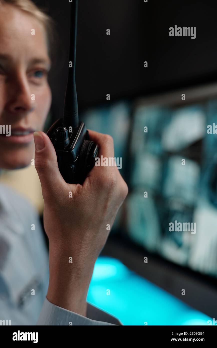 Focus on hand of young security guard with transceiver reporting about ...