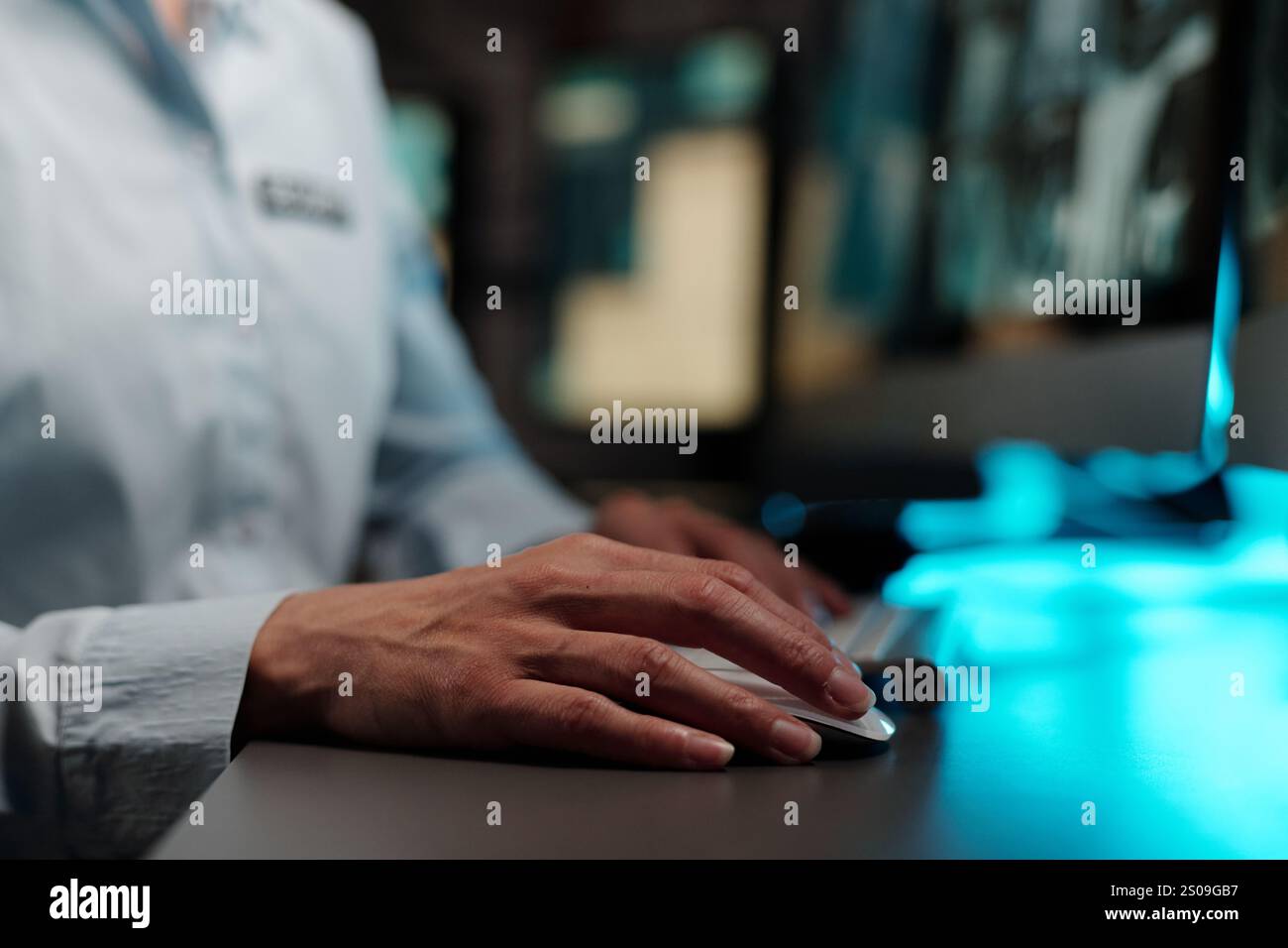 Hand of young female security guard on computer mouse during work with ...