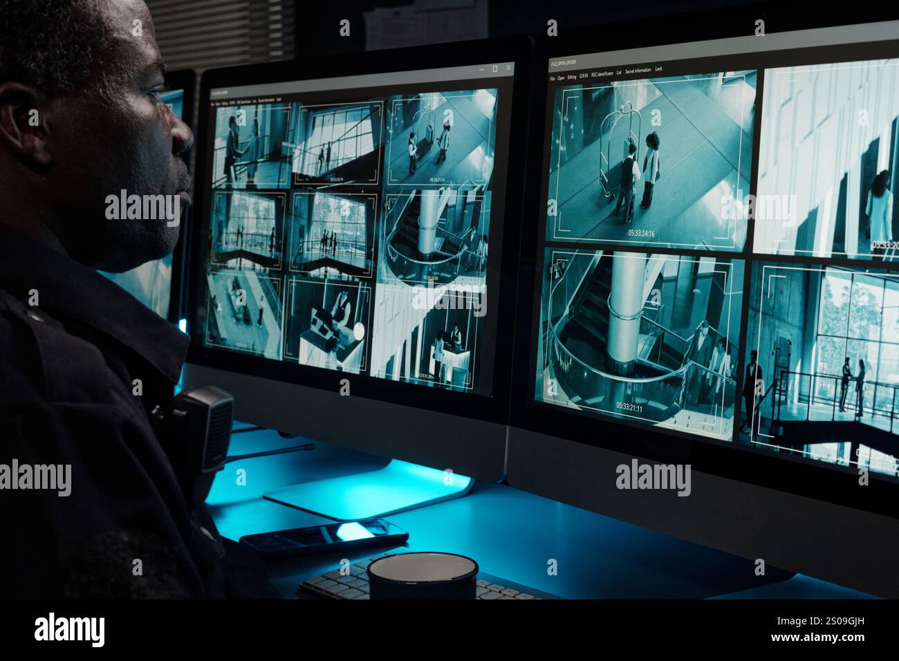 Serious African American security guard watching cctv video in ...