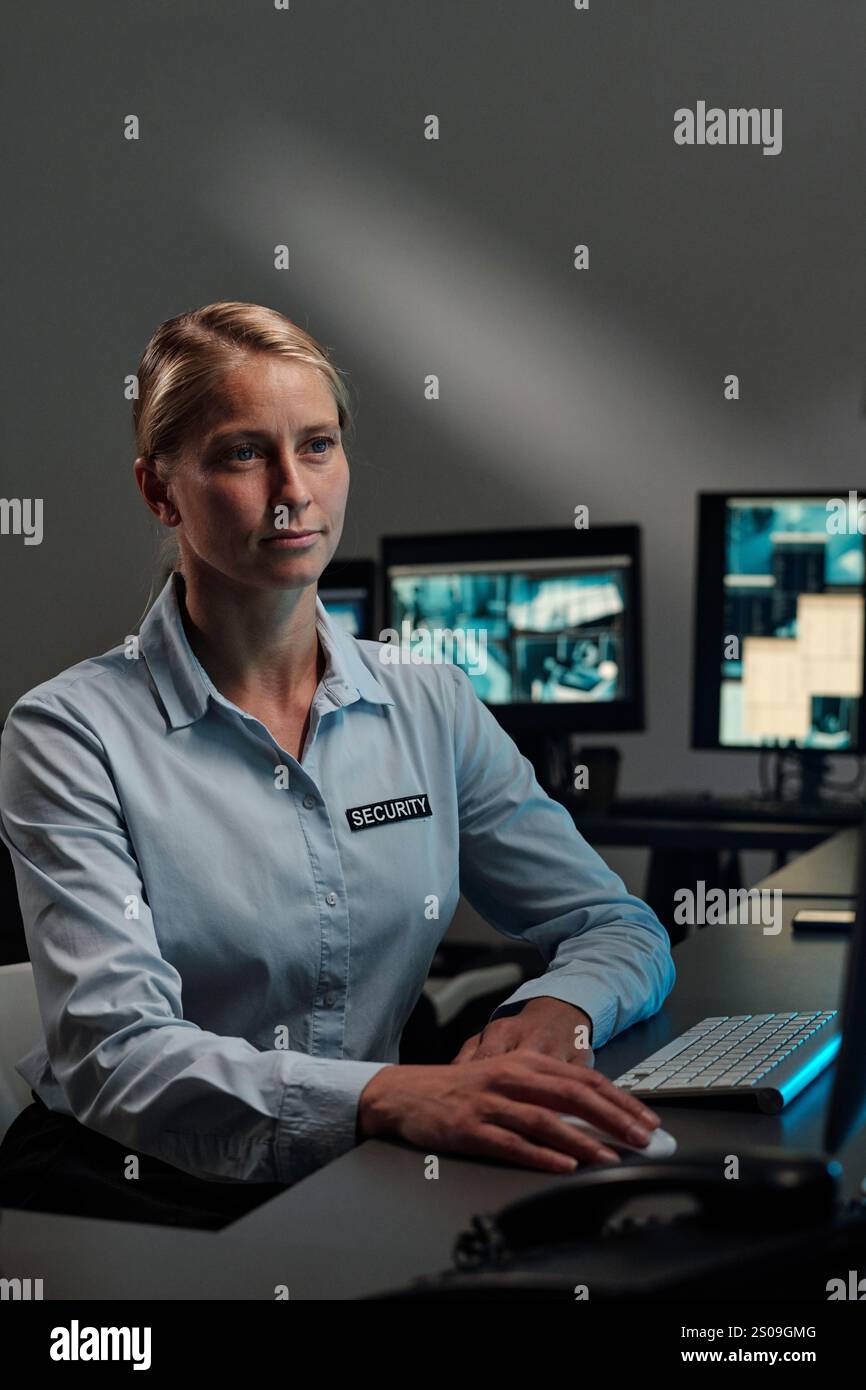Young blond female security guard or officer of observation room ...