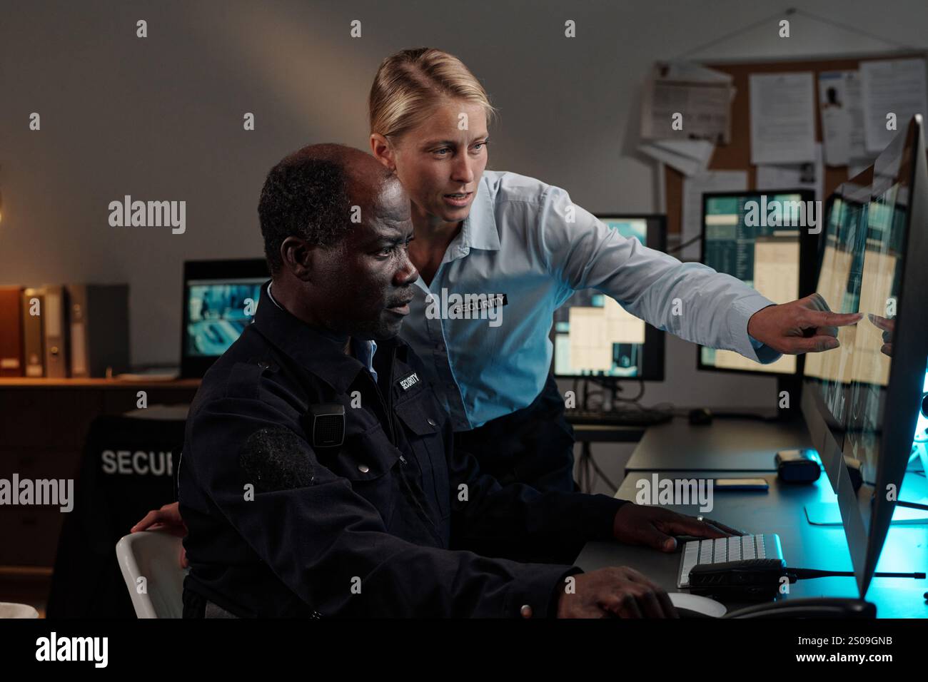 Young confident female security guard standing next to male colleague ...