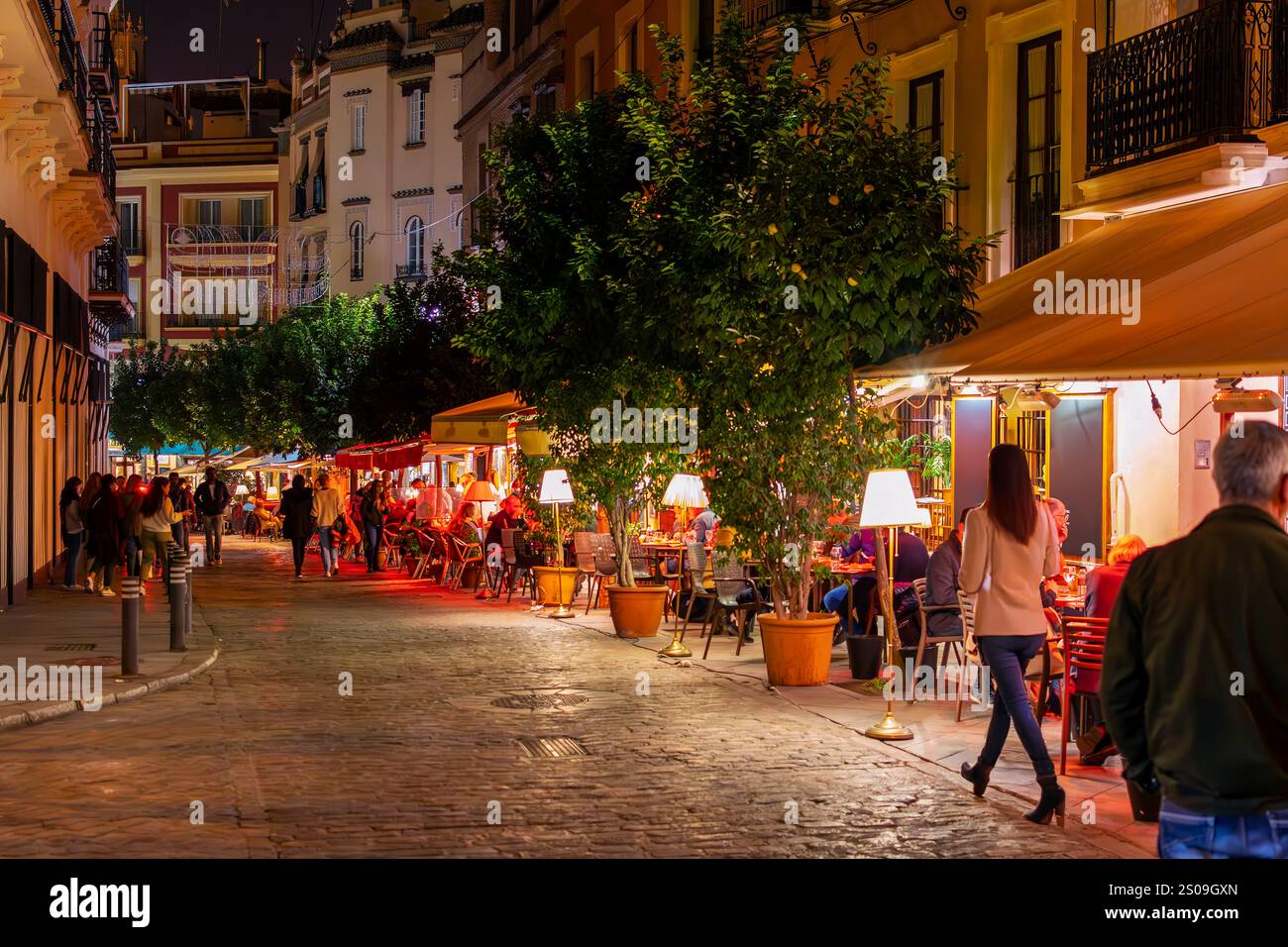 Late night diners at illuminated sidewalk cafes in the touristic Barrio ...