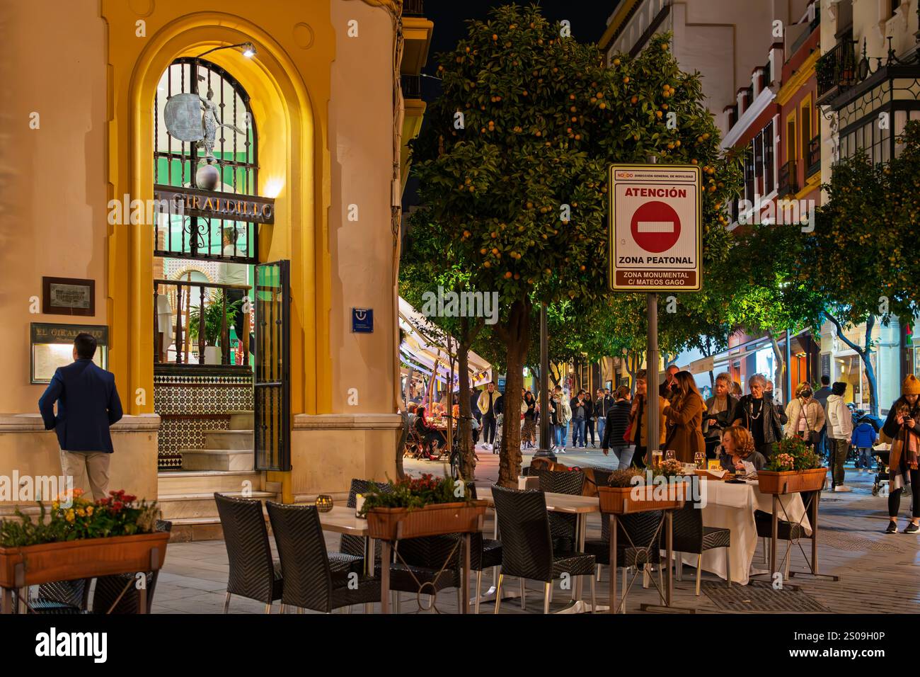 Late night diners at illuminated sidewalk cafes in the touristic Barrio ...