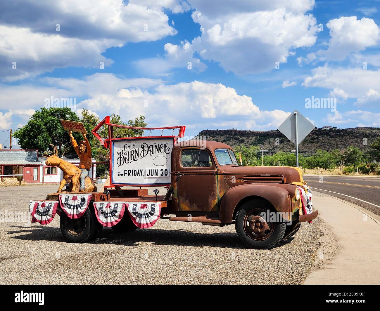 A barn dance sign and wooden sculpture are loaded in the bed of an old ...