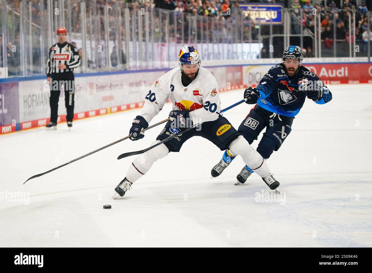 Andreas Eder (EHC Red Bull Muenchen, #20) am Puck und im Zweikampf ...