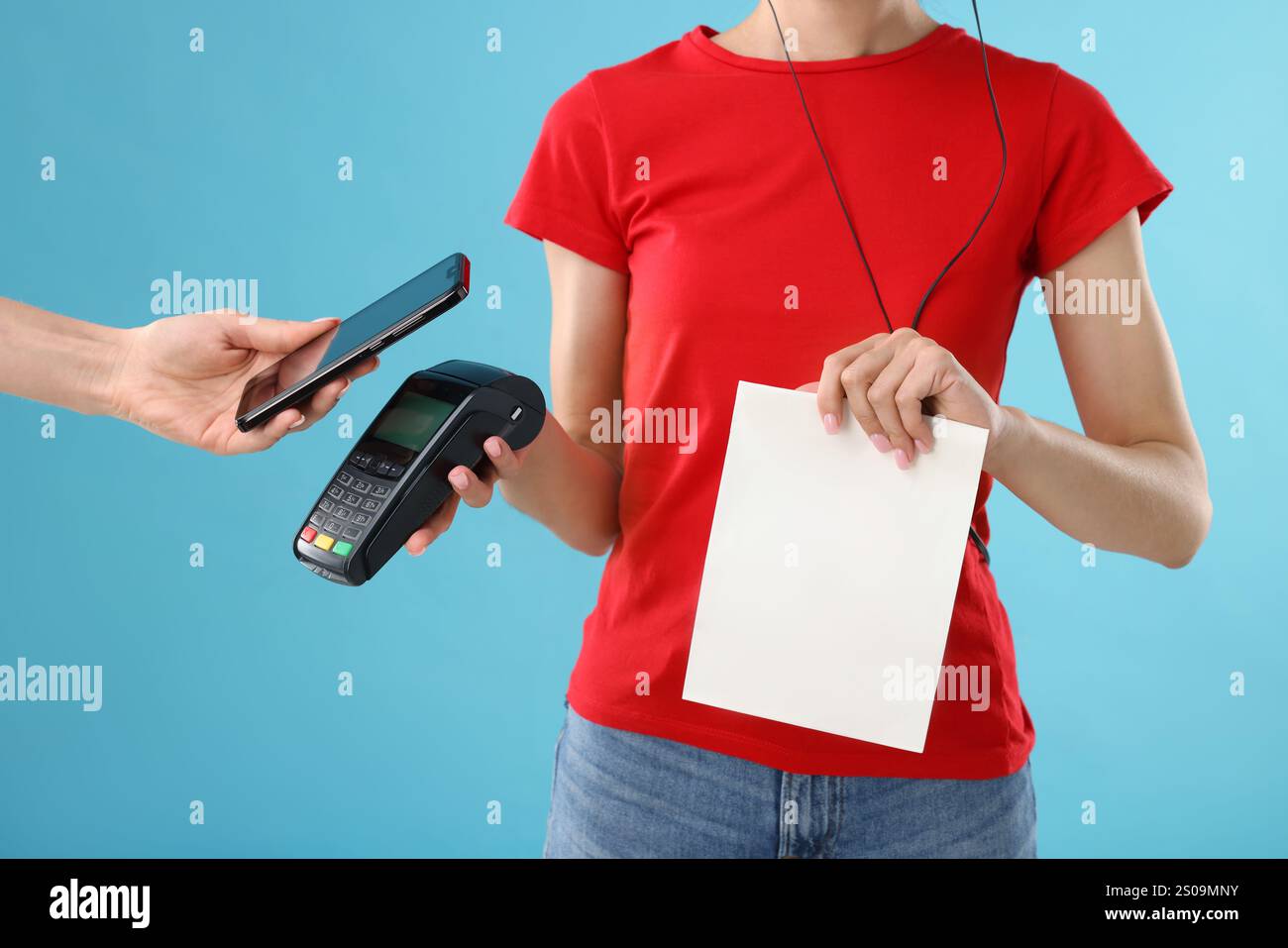 Fast-food worker taking payment from client via terminal on light blue ...