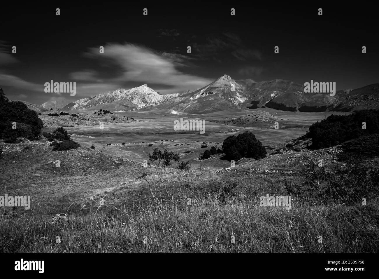 Black and white landscape with dramatic skies and barren hills ...