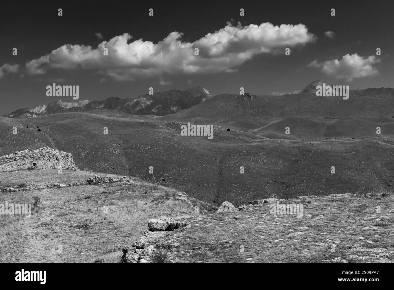 Black and white landscape with dramatic skies and barren hills ...