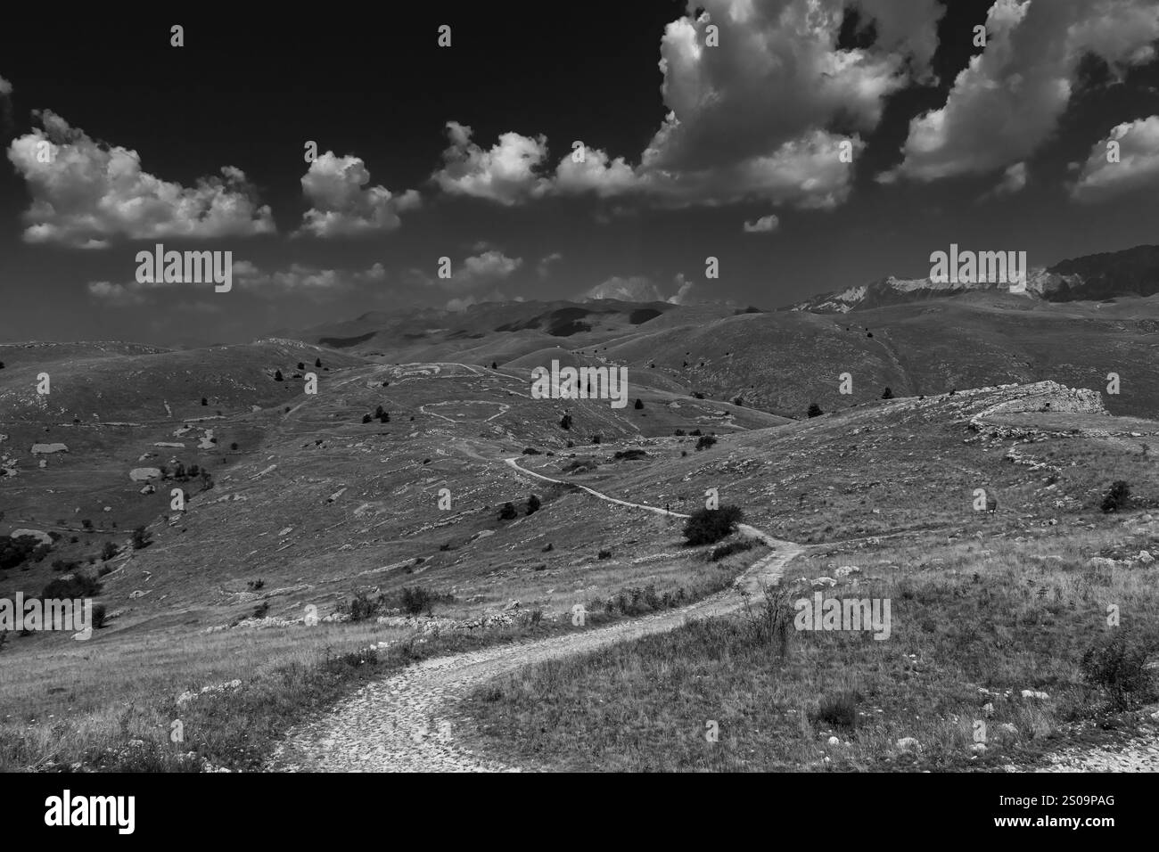Black and white landscape with dramatic skies and barren hills ...