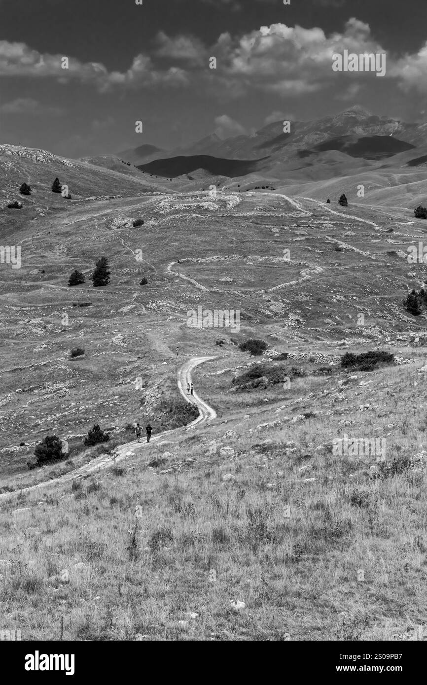 Black and white landscape with dramatic skies and barren hills ...