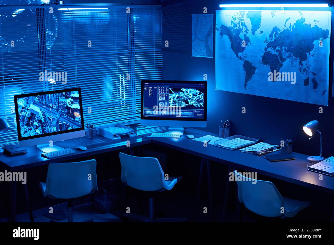 Desks with computer monitors with location data on screens standing ...