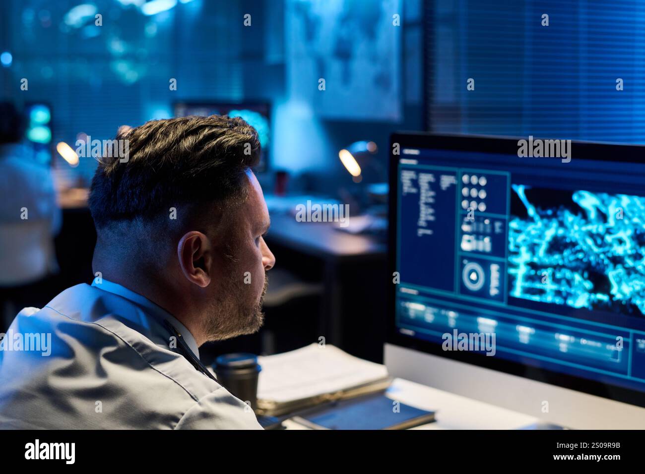 Focus on mature male officer in uniform sitting by workplace and ...