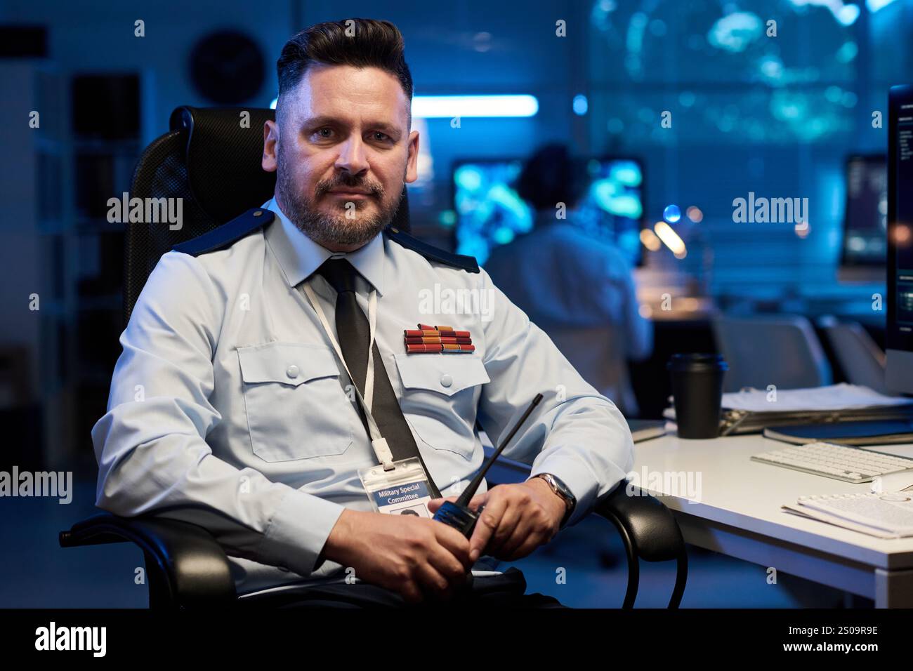 Confident mature officer wearing uniform and tie looking at camera ...