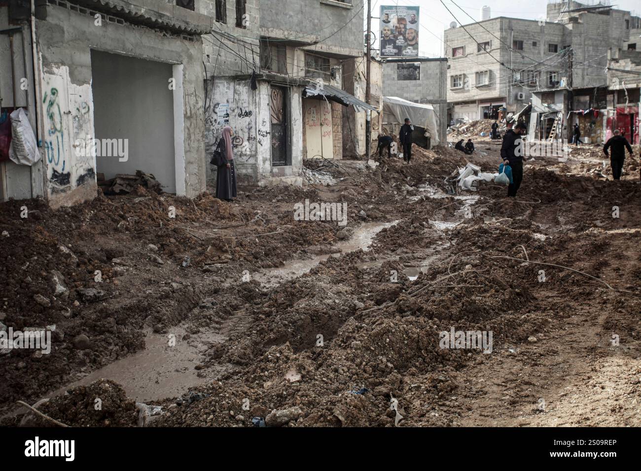 Tulkarm, Palestine. 26th Dec, 2024. Palestinians walk and inspect their ...