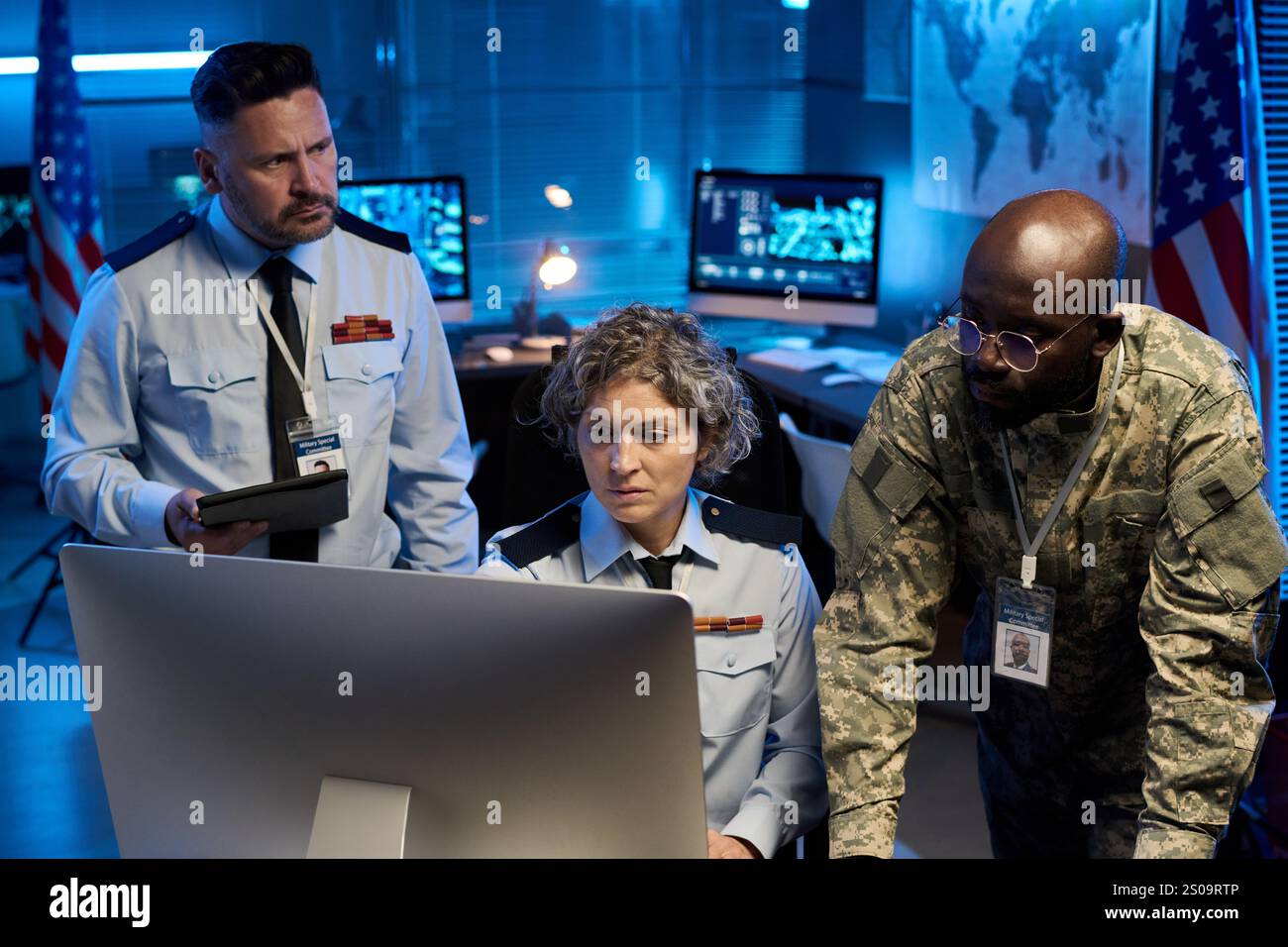 Group of three intercultural military officers in uniform looking at ...