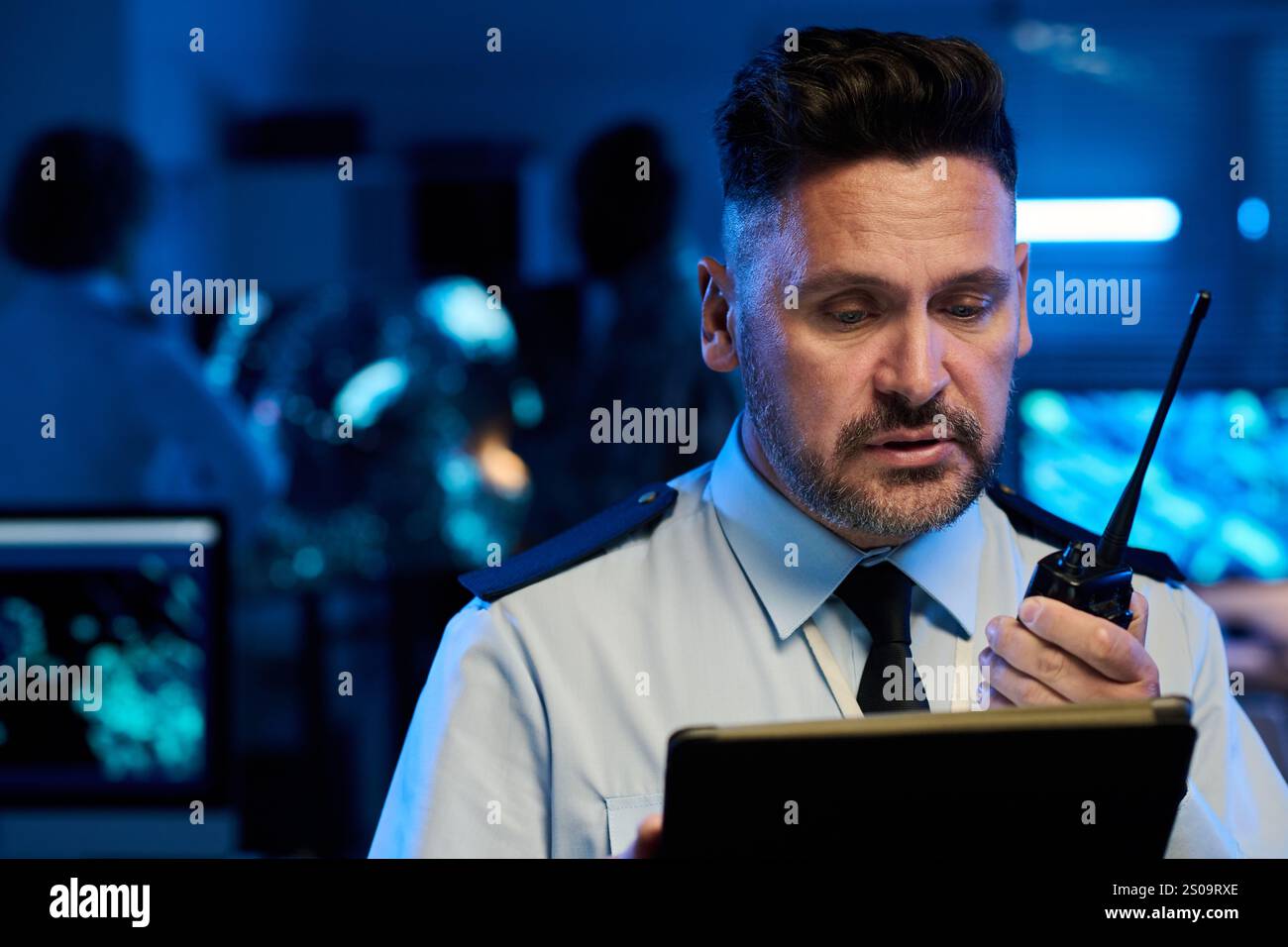Male officer or military command center worker with walkie-talkie and ...