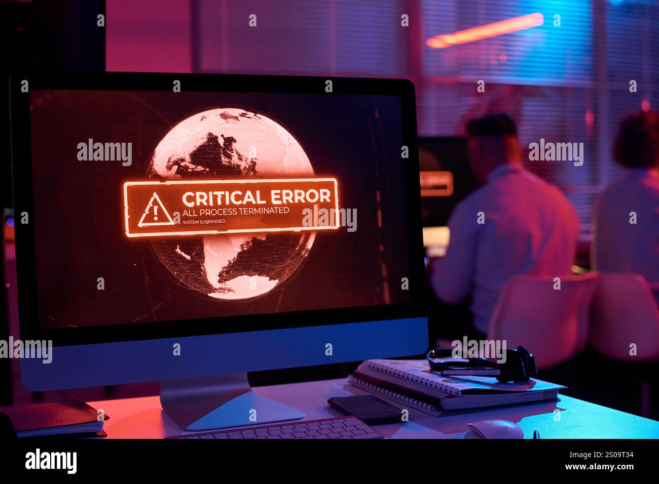 Workplace of IT engineer in dark server room with computer screen ...