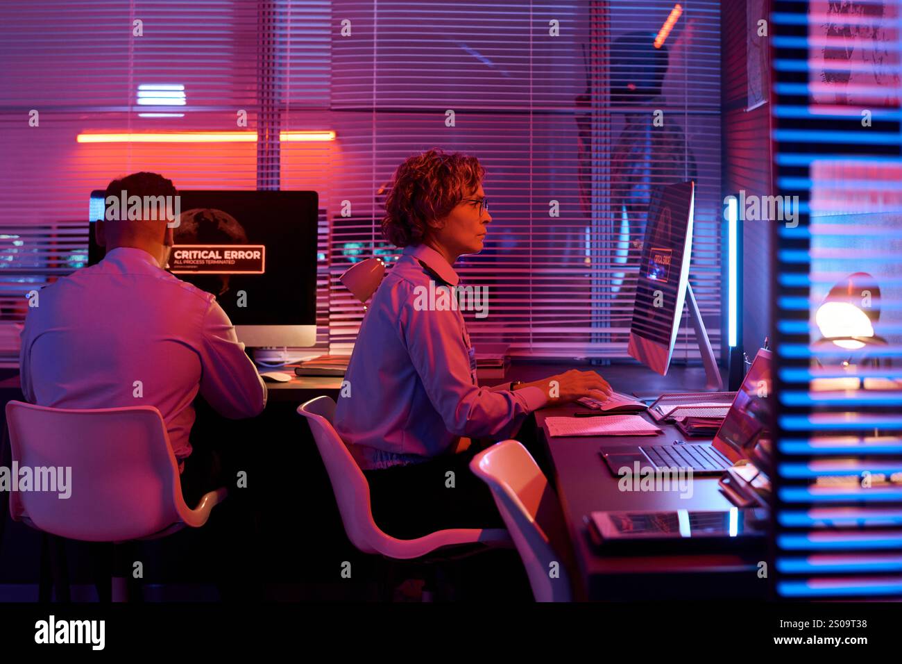 Side view of serious mature female officer in uniform sitting by desk ...